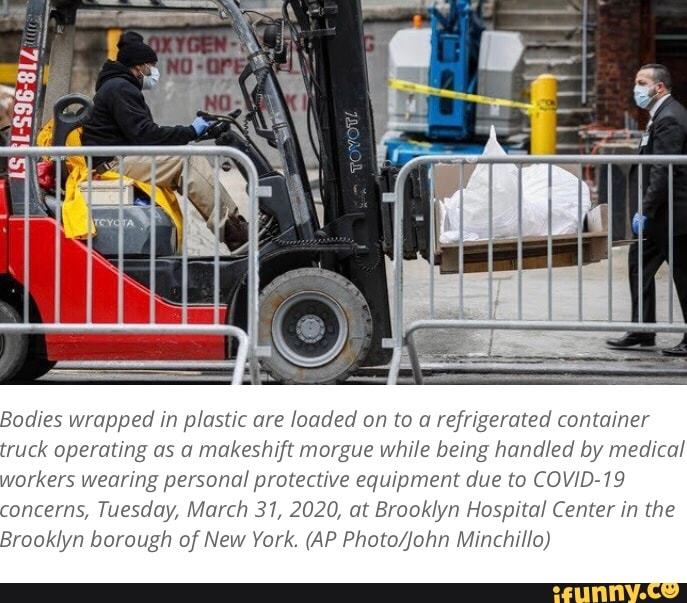 Bodies wrapped in plastic are loaded on to a refrigerated container ...