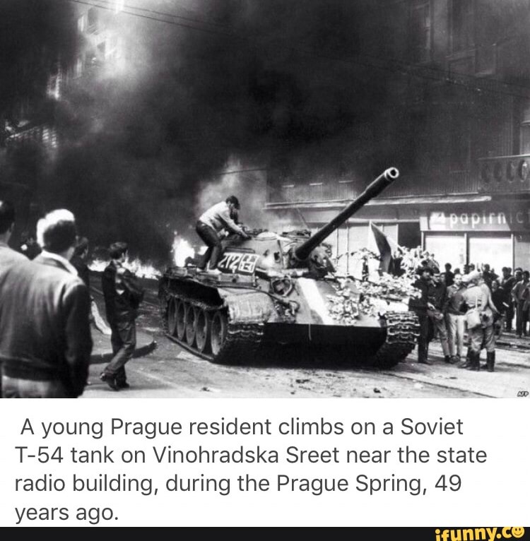 A young Prague resident climbs on a Soviet T-54 tank on Vinohradska ...