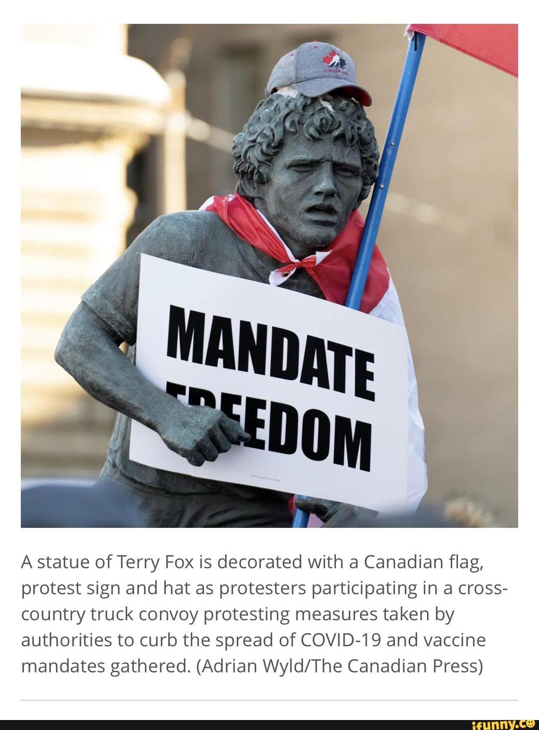 A statue of Terry Fox is decorated with a Canadian flag, protest sign ...